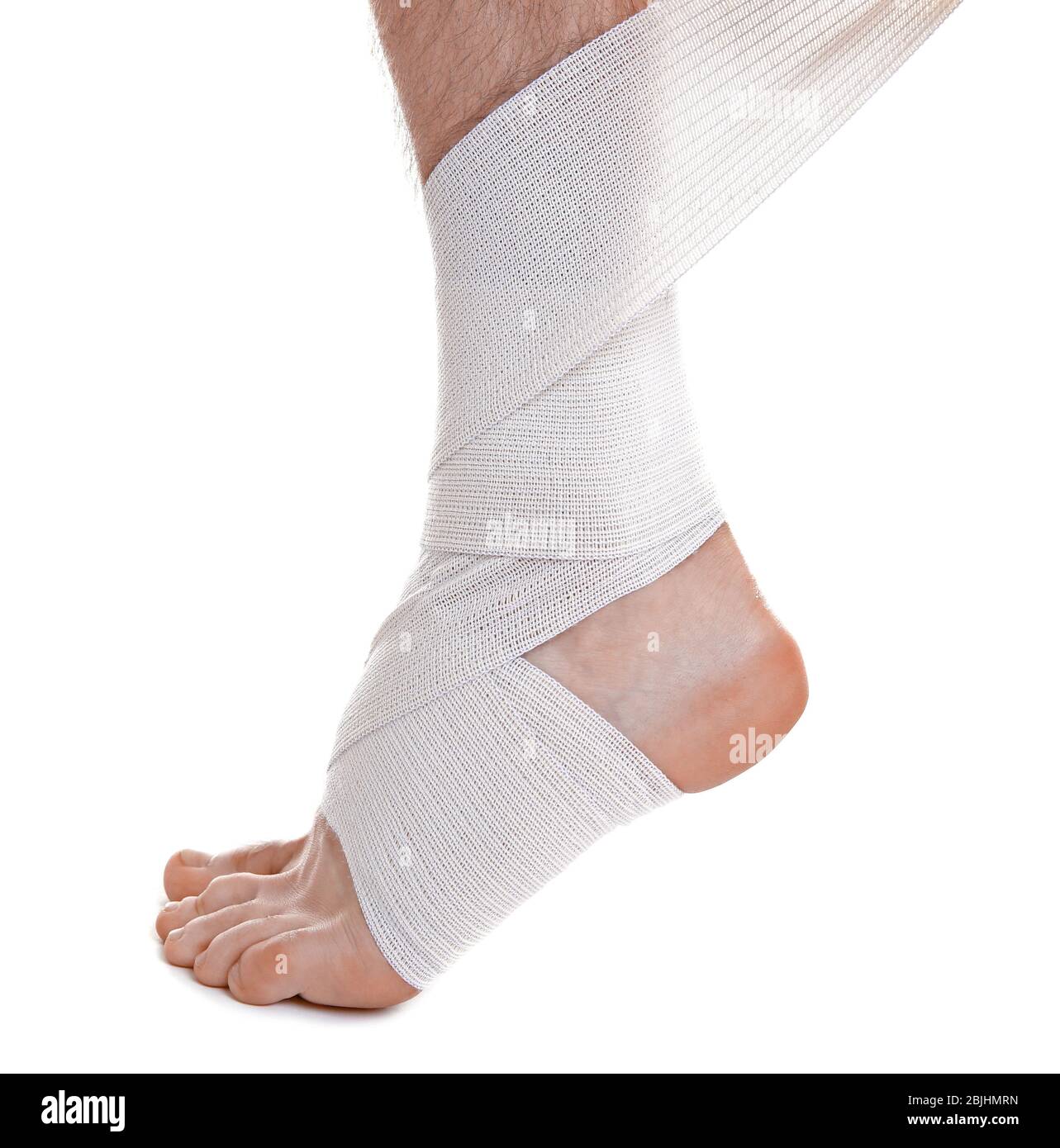 Applying bandage onto leg of young man, on white background Stock Photo ...