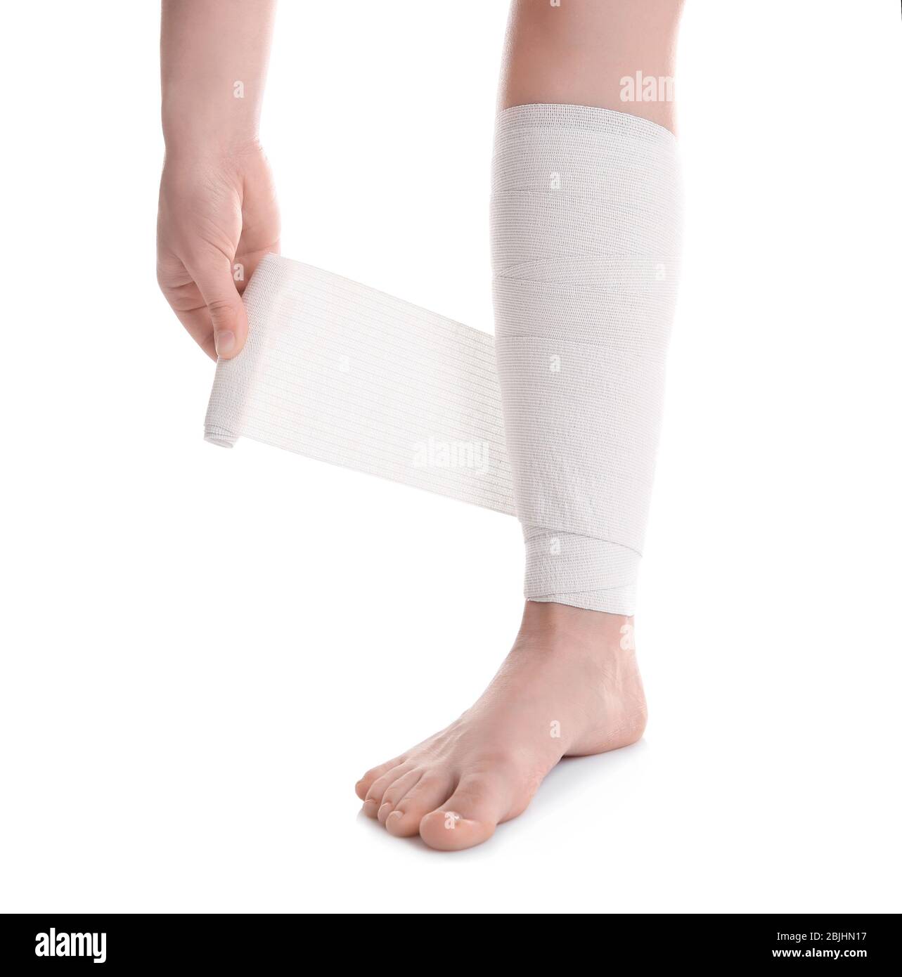 Young woman applying bandage onto leg, on white background Stock Photo ...