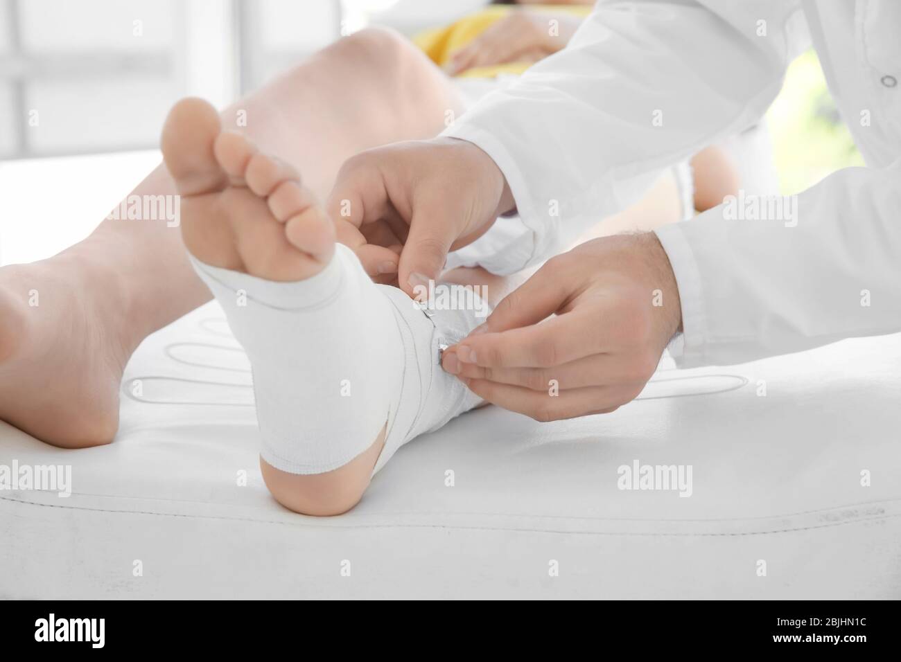 Doctor applying bandage onto patient's leg in clinic, closeup Stock ...