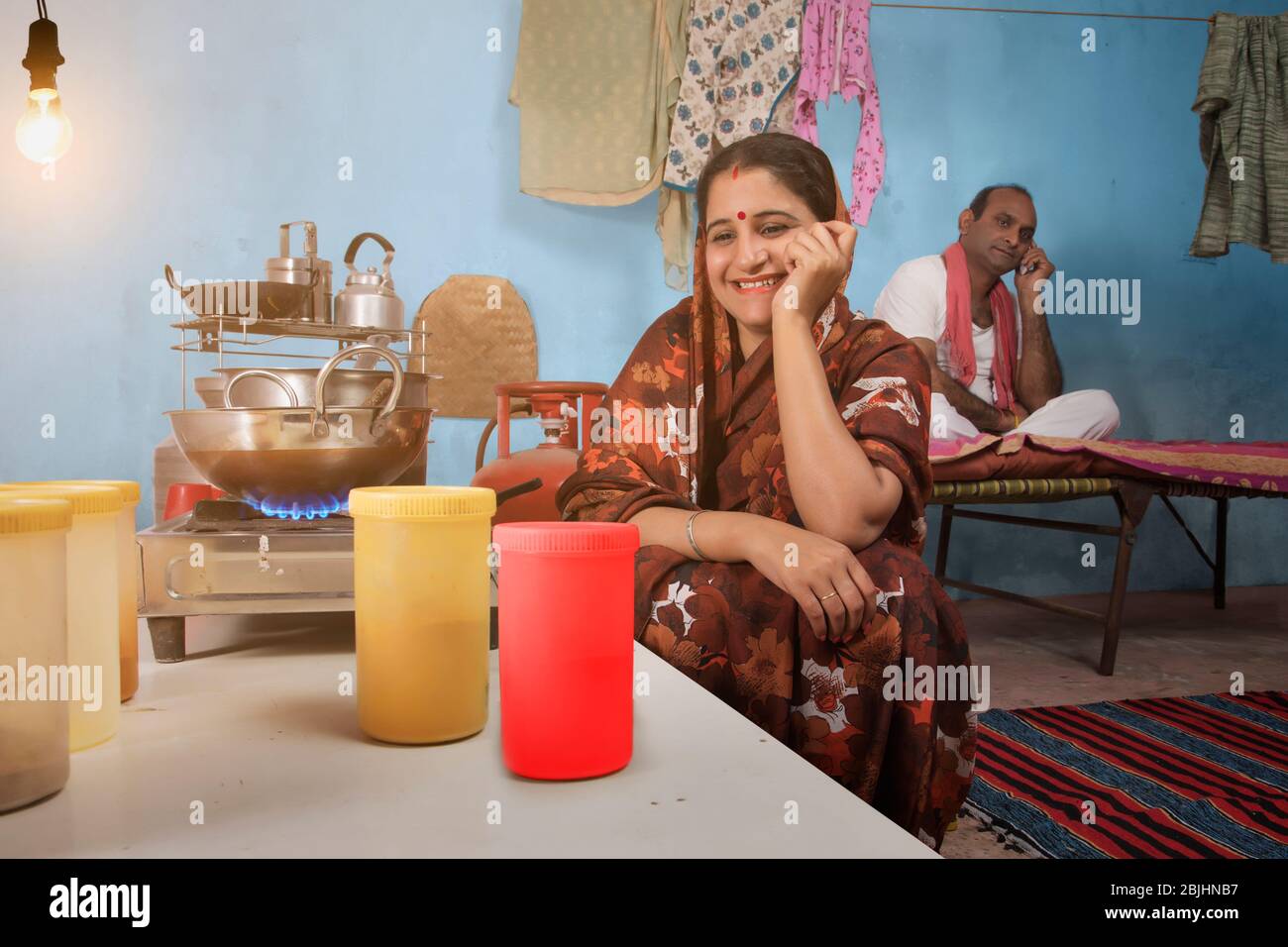 Indian Woman Sitting In Kitchen Cooking Food Stock Photo - Alamy