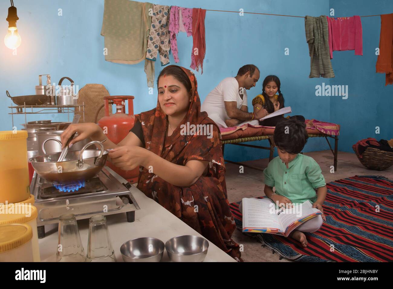 Childs studying in the kitchen while his mother is cooking Stock Photo ...