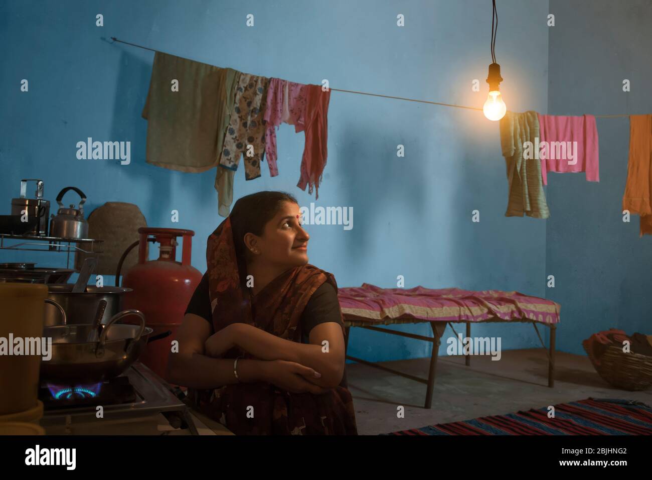 Indian Woman Cooking Food Looking At Light Bulb Stock Photo - Alamy