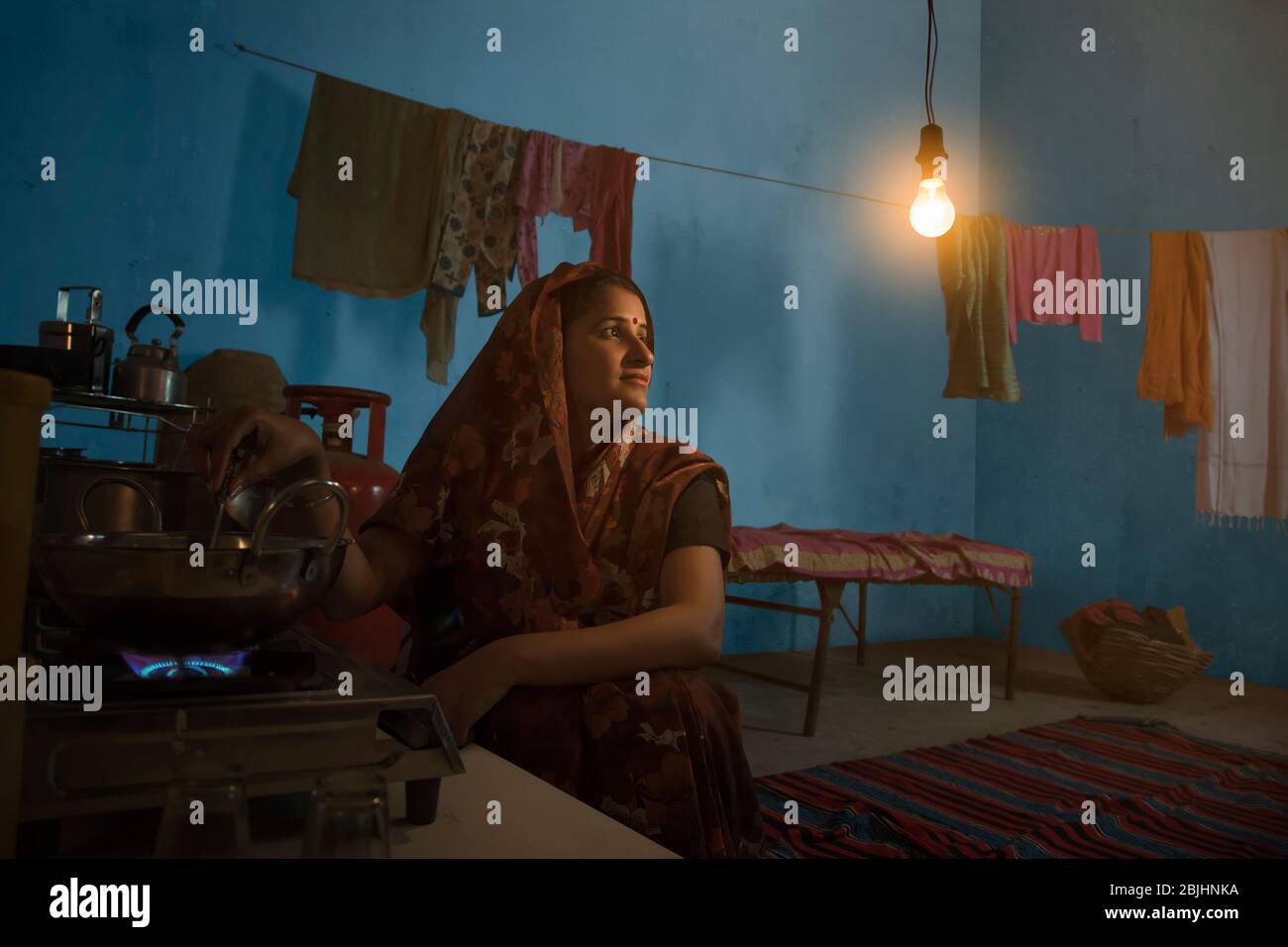 Indian Woman Cooking Food Looking At Light Bulb Stock Photo - Alamy