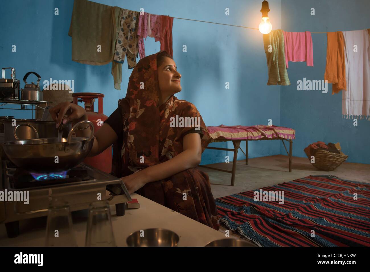 Indian Woman Cooking Food Looking At Light Bulb Stock Photo - Alamy
