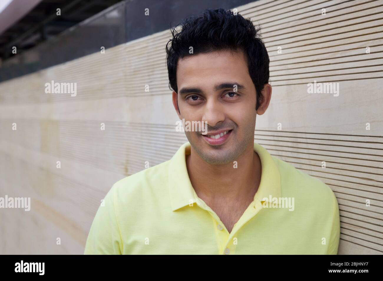 Portrait of a man leaning against a wall Stock Photo - Alamy