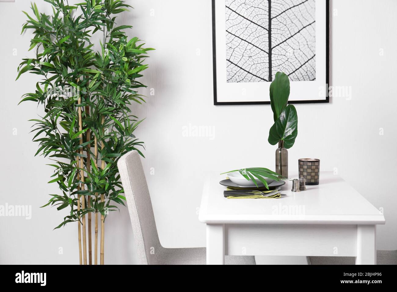 Table setting with green tropical leaves in cafe Stock Photo - Alamy