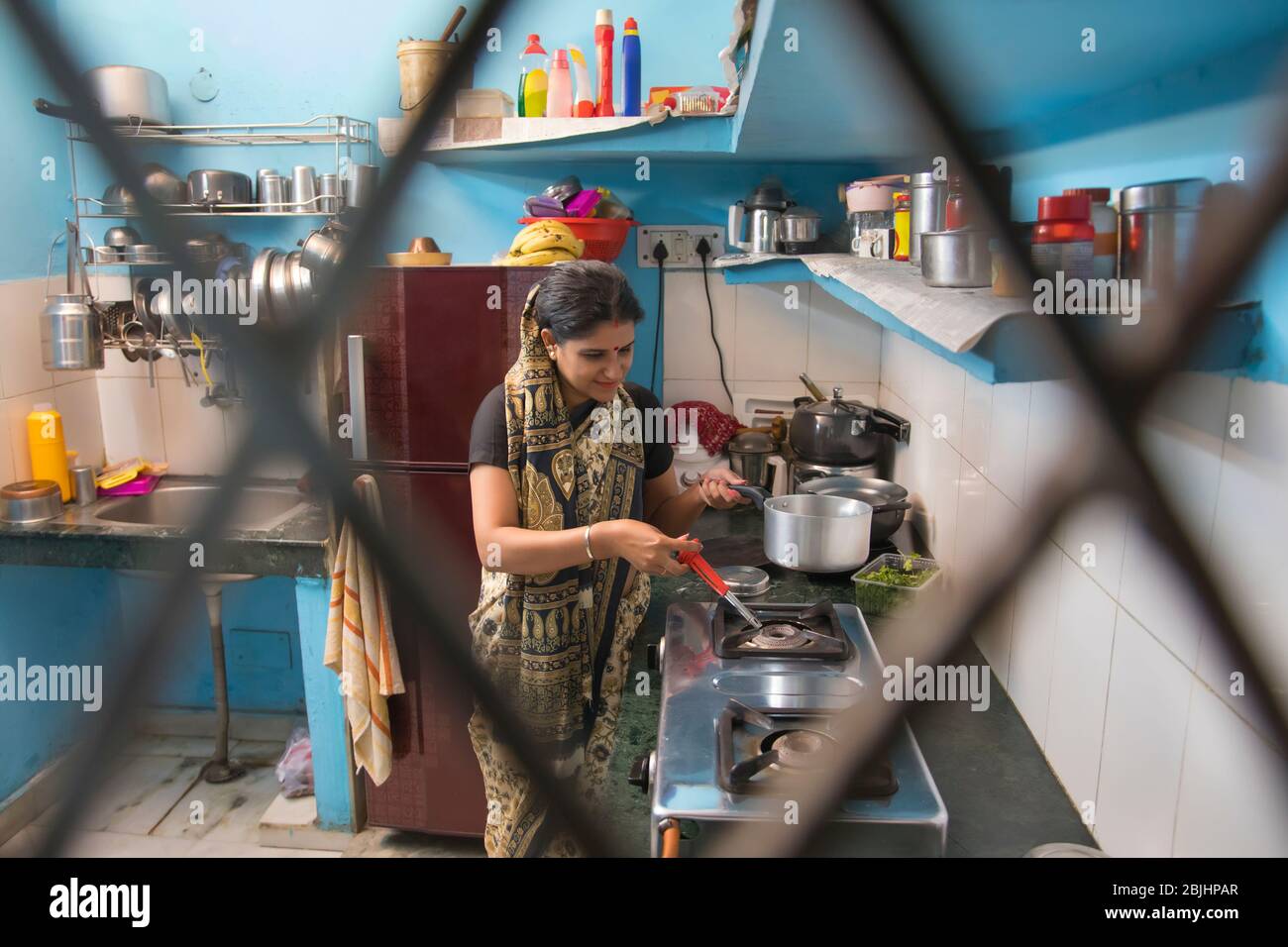 Indian Woman In Kitchen Cooking Food Stock Photo - Alamy