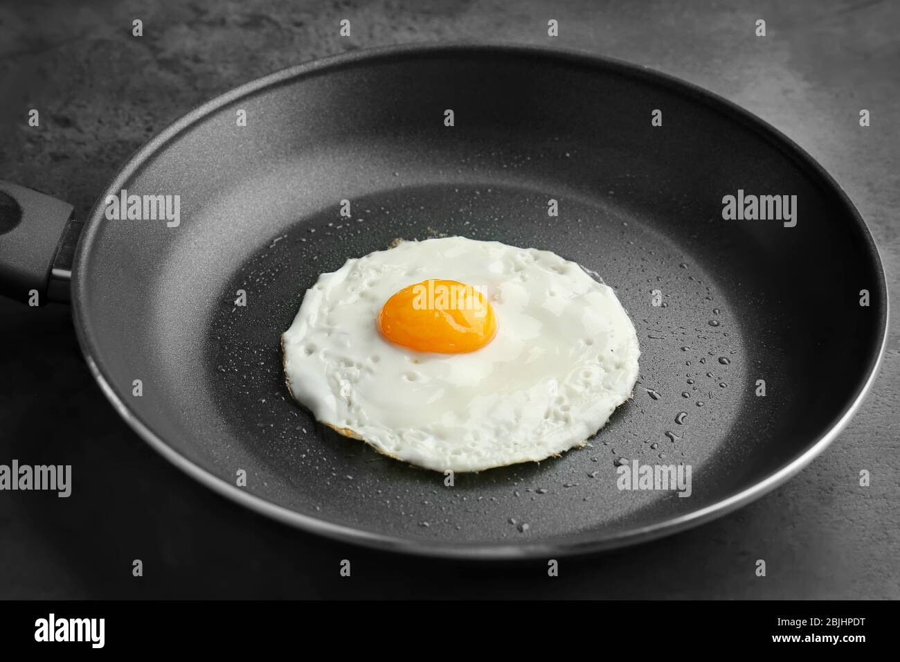 Homemade over easy fried egg in pan on dark background Stock Photo - Alamy