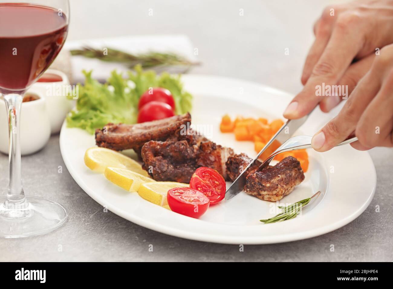 Young man eating delicious ribs in restaurant, closeup Stock Photo - Alamy