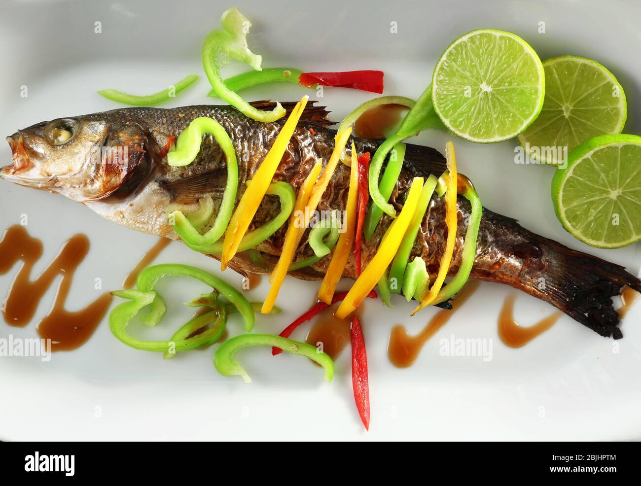 Serving plate with delicious fish in sauce and vegetables, closeup ...
