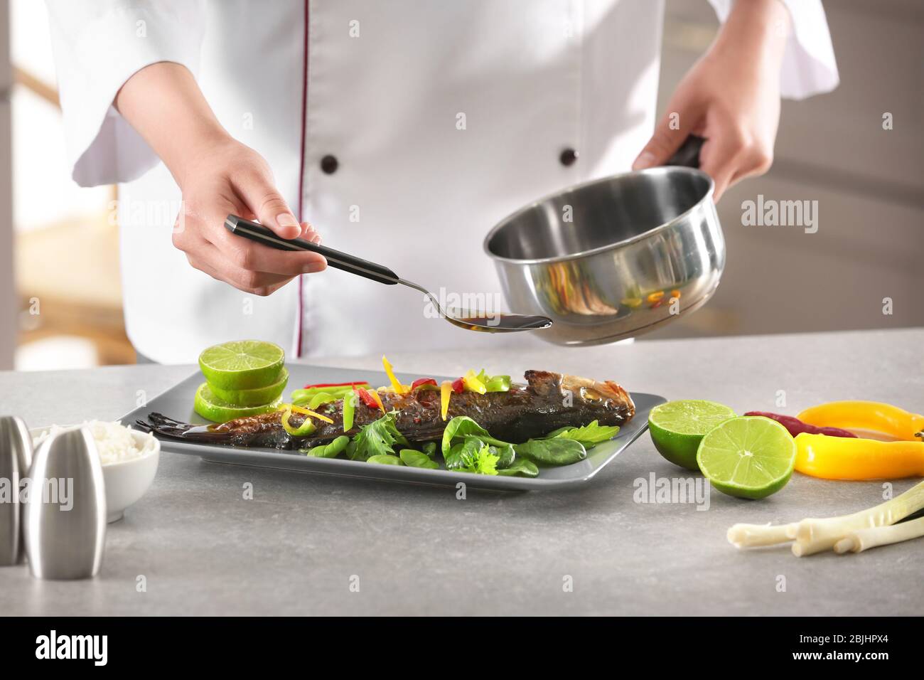 Chef pouring fish with delicious sauce in restaurant Stock Photo - Alamy