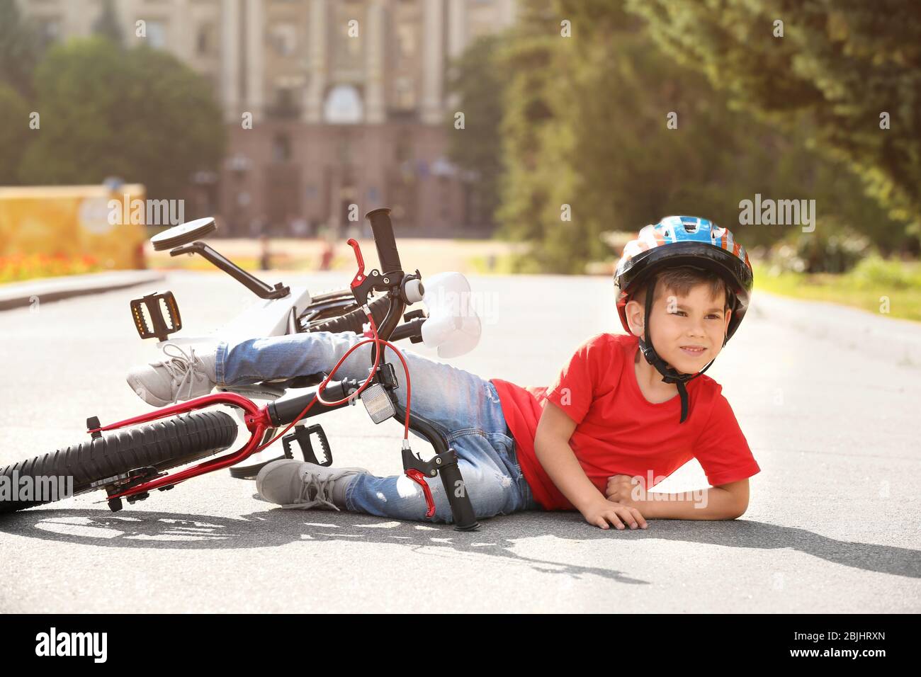 Cute little boy fallen off his bicycle outdoors Stock Photo - Alamy