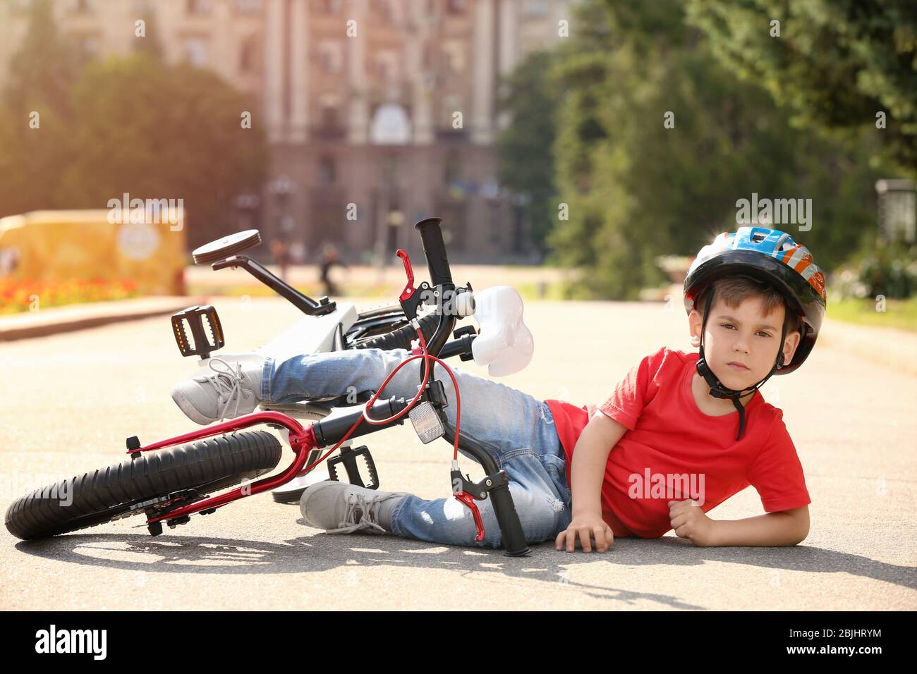 Cute little boy fallen off his bicycle outdoors Stock Photo - Alamy