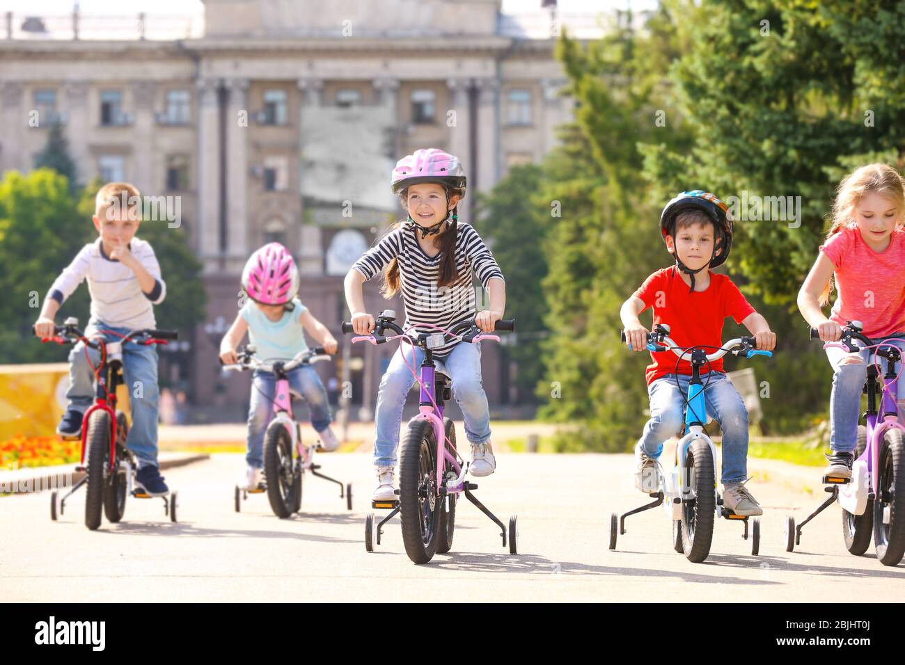 Cute little children riding bicycles outdoors on sunny day Stock Photo ...