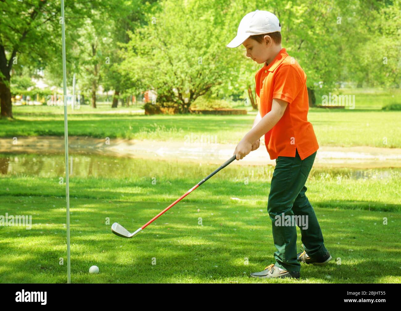 Cute boy playing golf on course in sunny day Stock Photo - Alamy