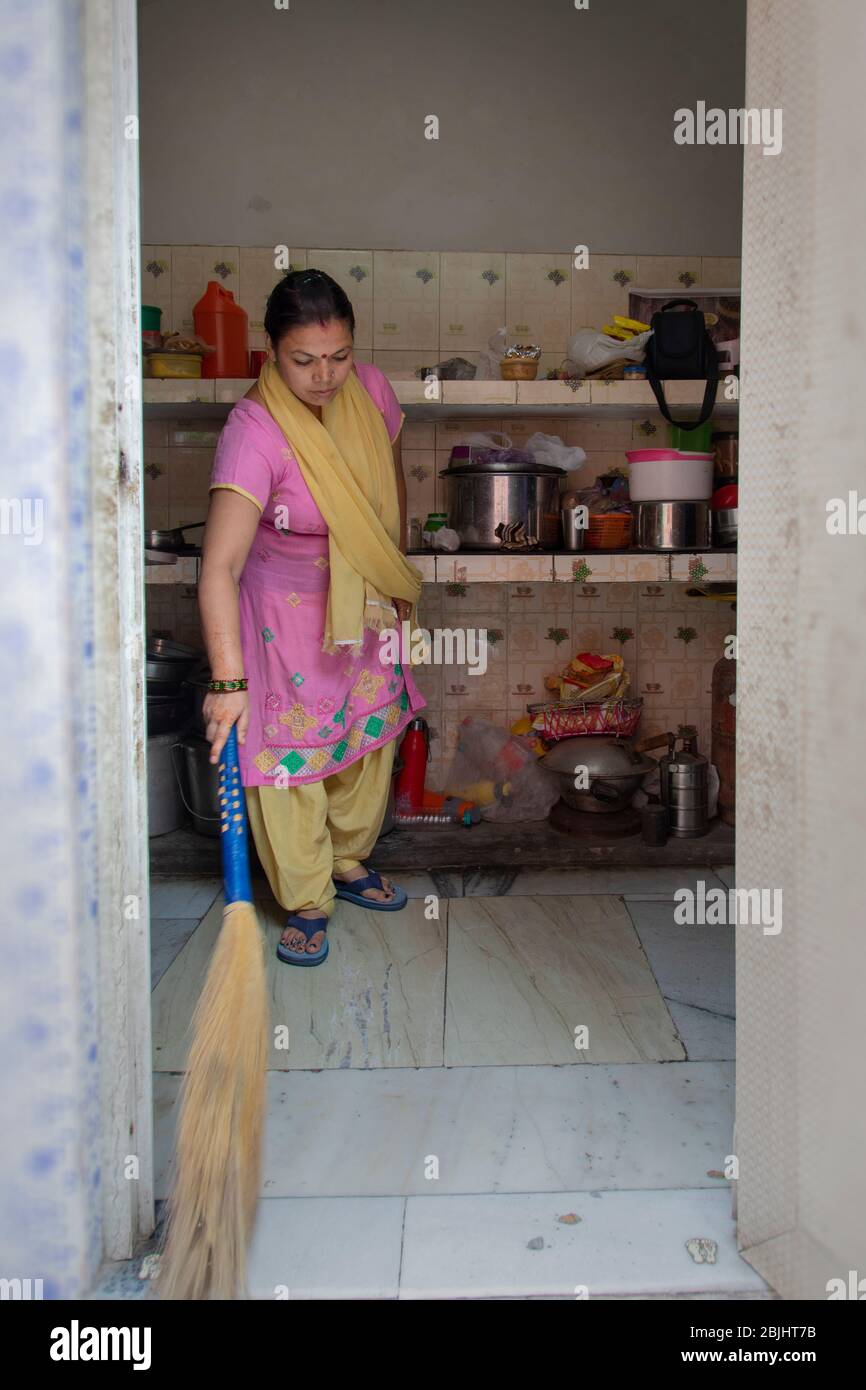woman cleaning kitchen with a broom Stock Photo - Alamy