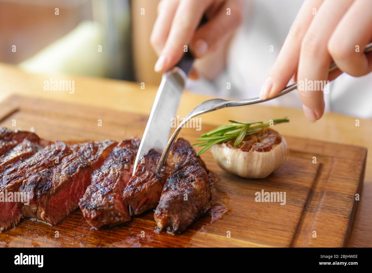 Young woman eating grilled steak in restaurant Stock Photo - Alamy