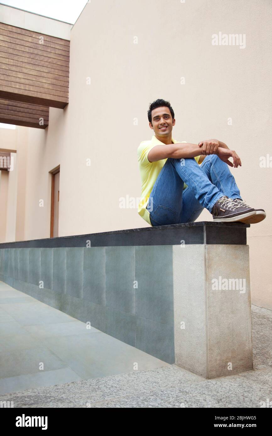 Man sitting on a wall Stock Photo - Alamy
