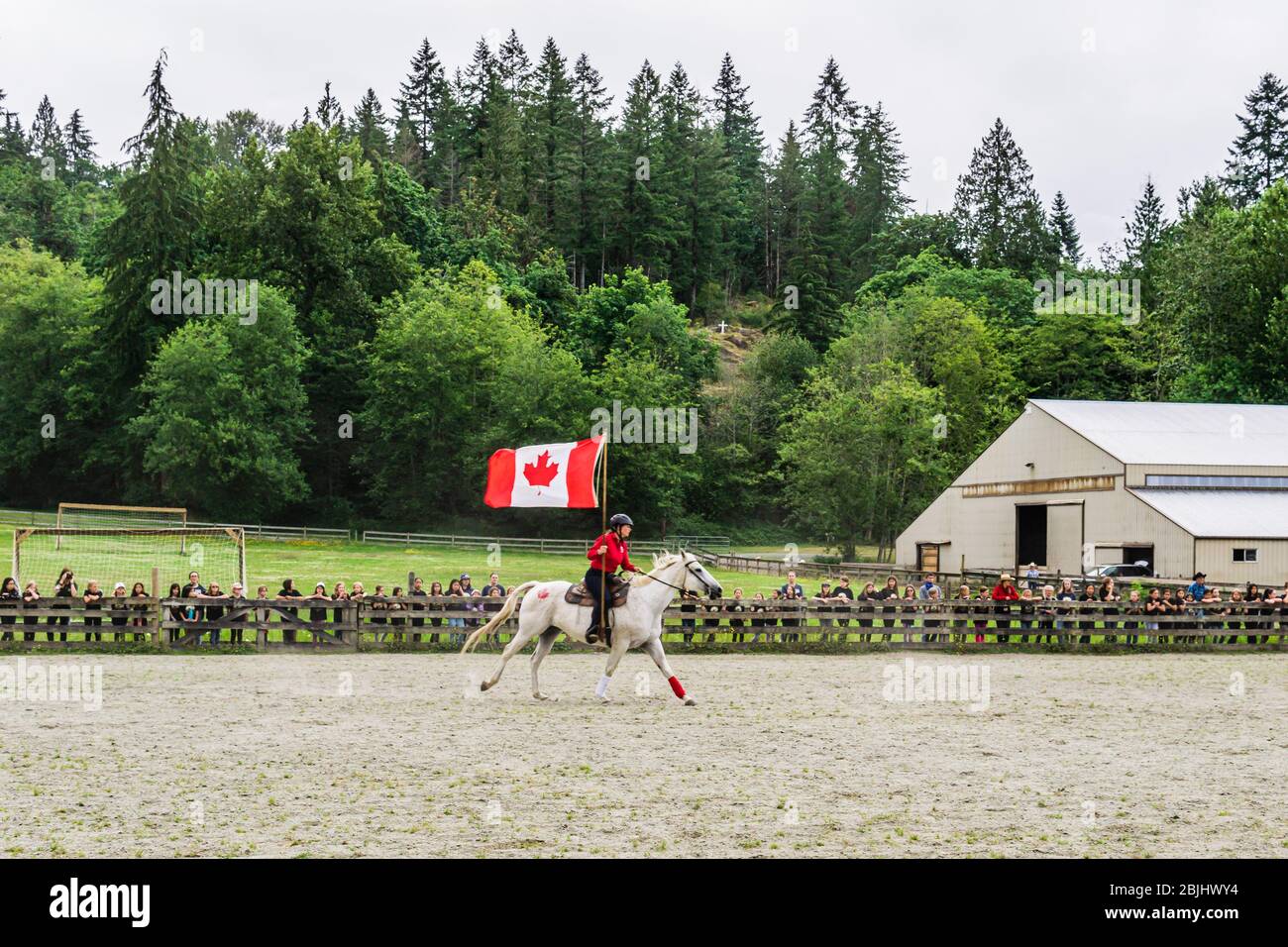 MAPLE RIDGE, CANADA - JULY 5, 2019: horse riders with flags on the ...