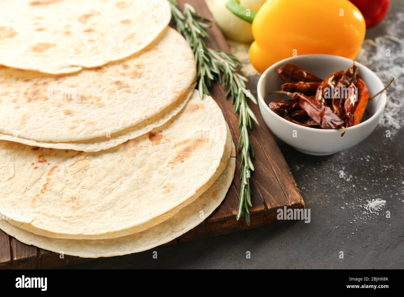 Board with delicious tortillas on kitchen table Stock Photo - Alamy