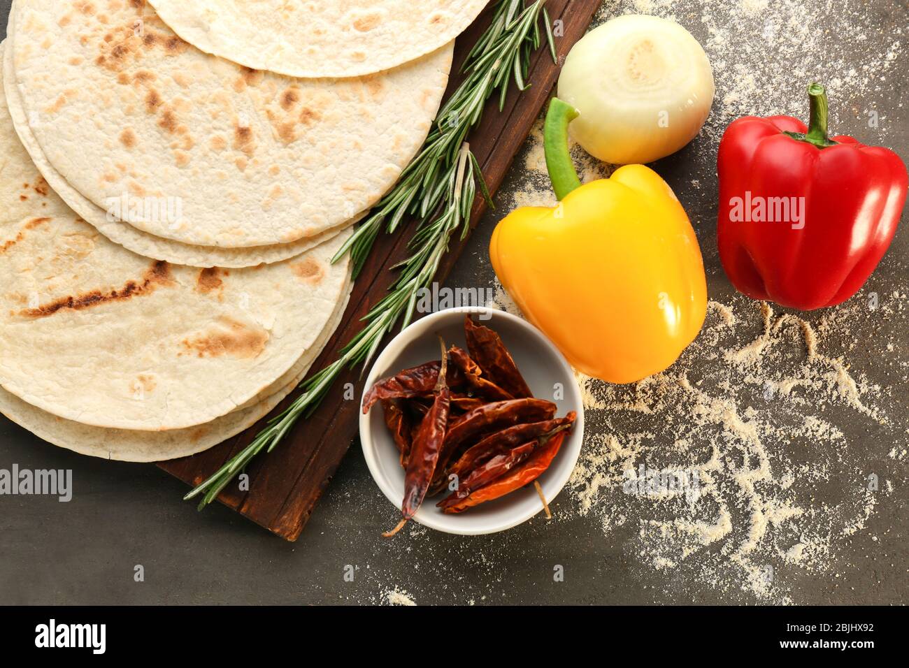 Board with delicious tortillas on kitchen table Stock Photo - Alamy