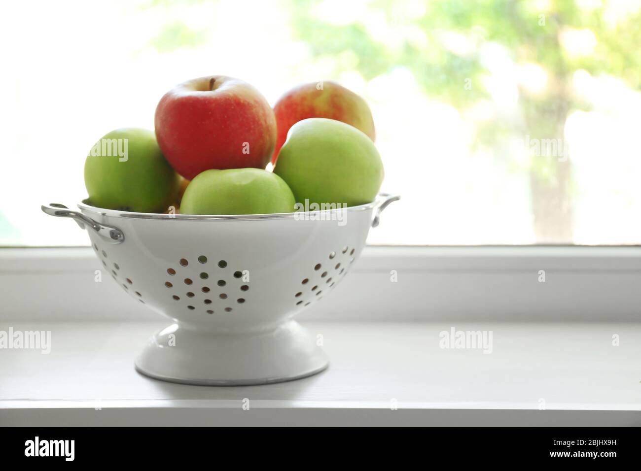 Colander with fresh apples on windowsill Stock Photo - Alamy
