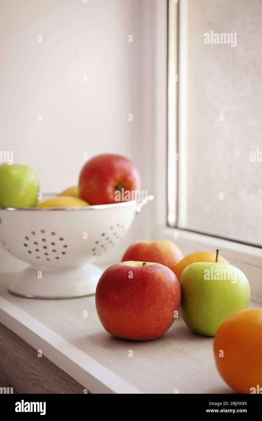 Fresh fruits and colander on windowsill Stock Photo - Alamy