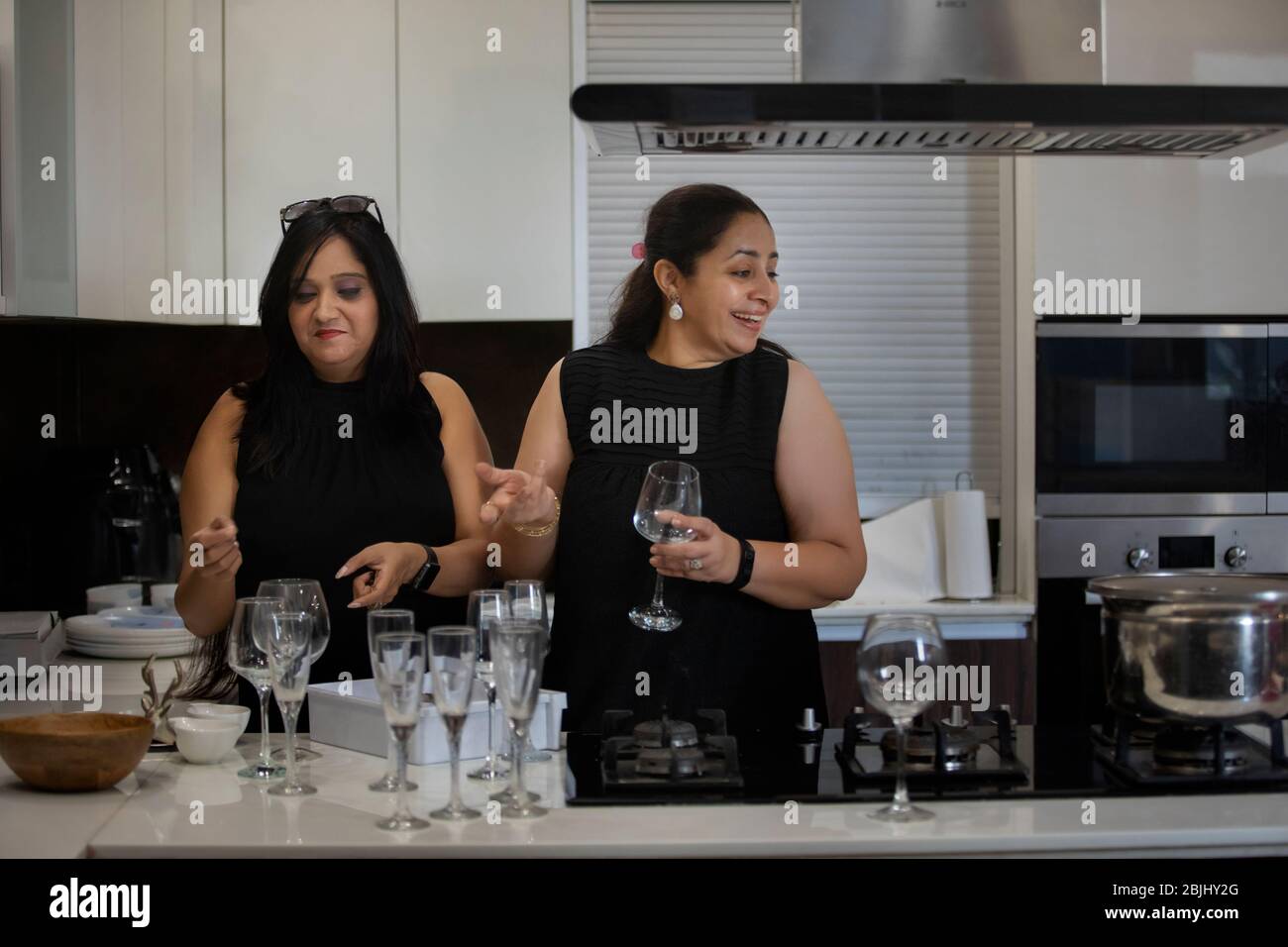 Friends sharing a light moment while pouring drinks at a party Stock ...