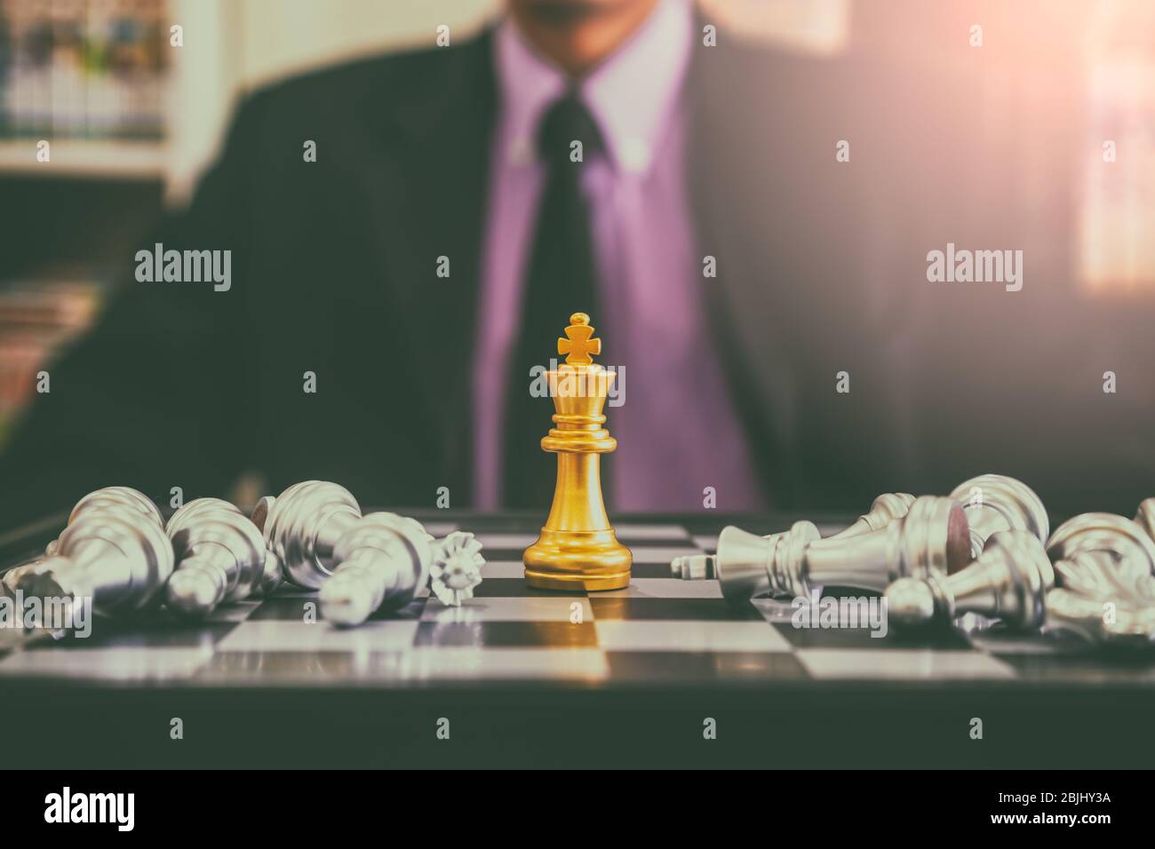 Chess game on chess board behind business man background. Business ...