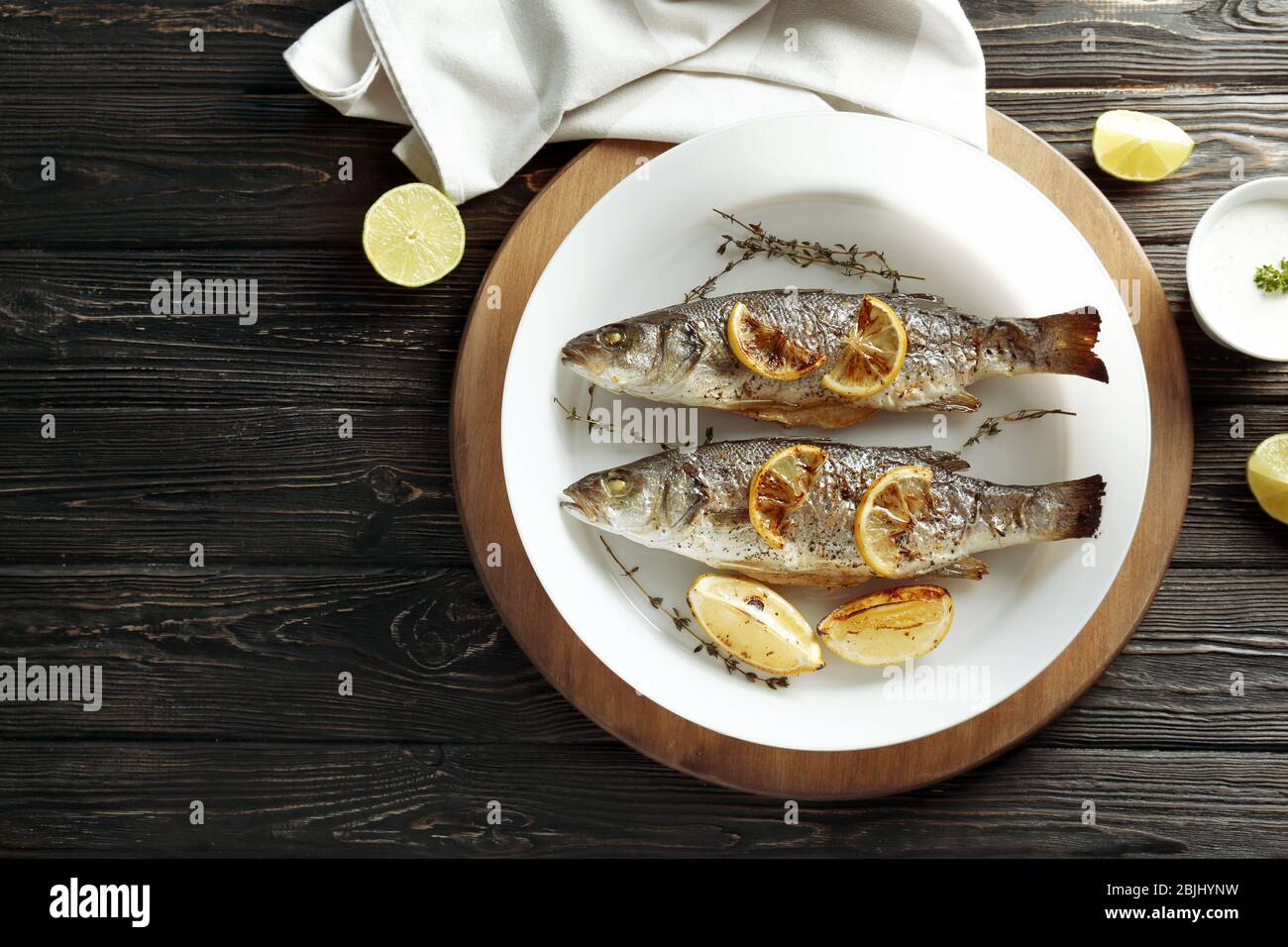 Delicious baked sea bass fish in white plate Stock Photo - Alamy
