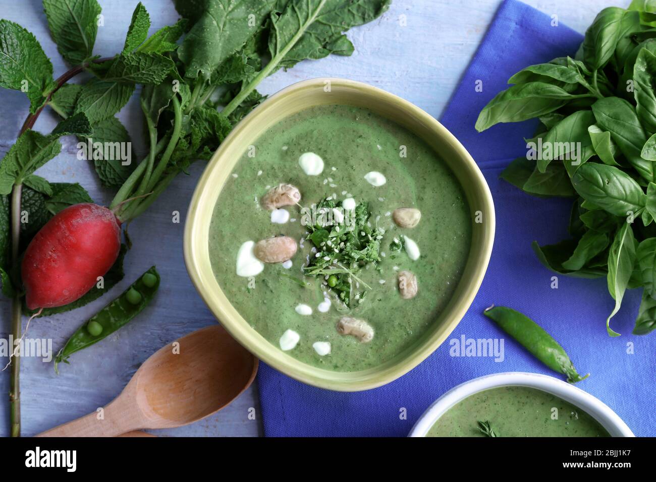 Delicious puree from green peas in bowl on wooden table Stock Photo - Alamy