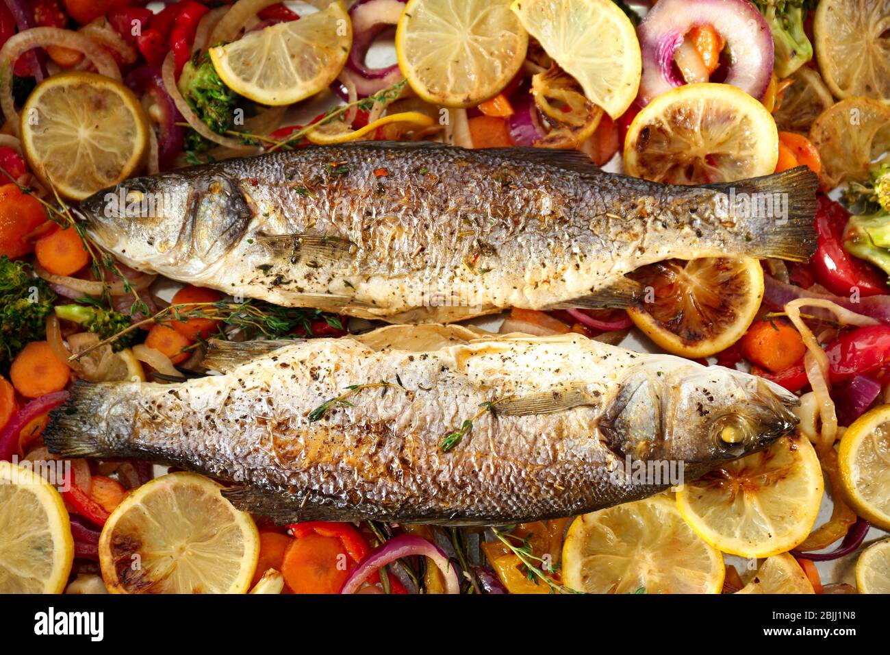 Tasty baked fish with vegetable garnish, top view Stock Photo - Alamy
