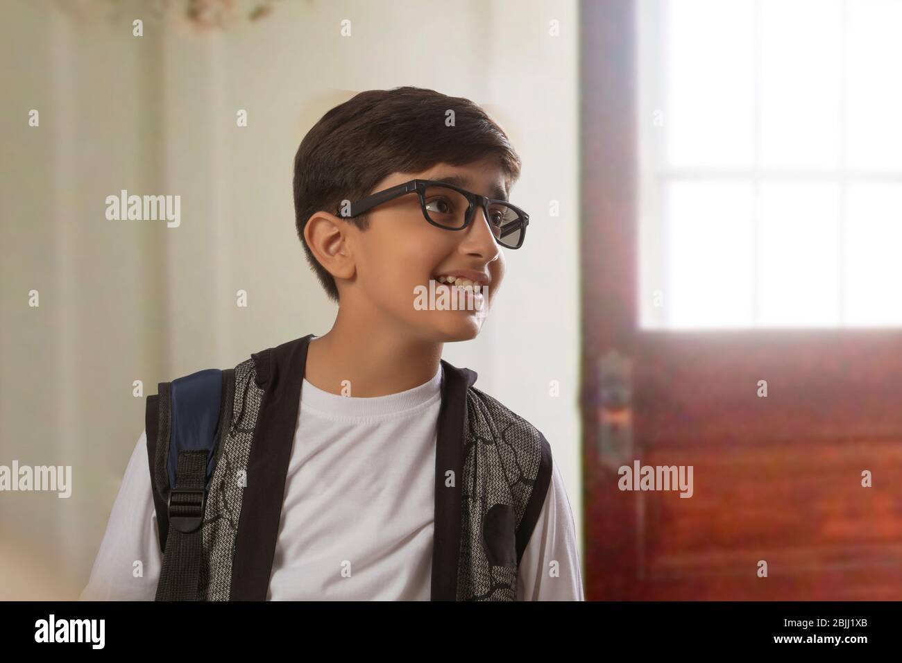 Portrait of a happy young boy holding a backpack. (Children Stock Photo ...