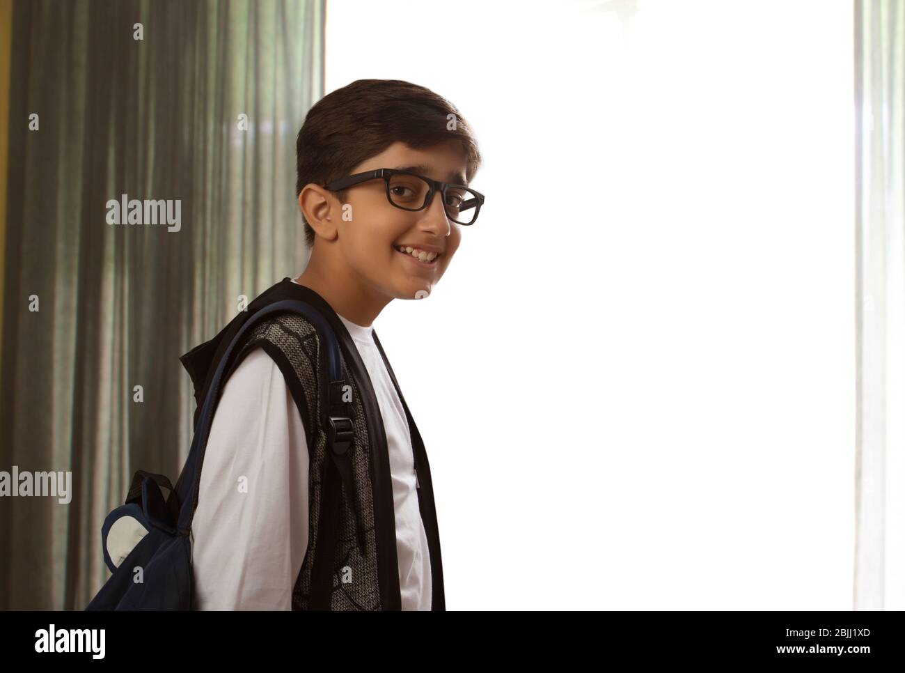 Portrait of a happy young boy holding a backpack. (Children Stock Photo ...