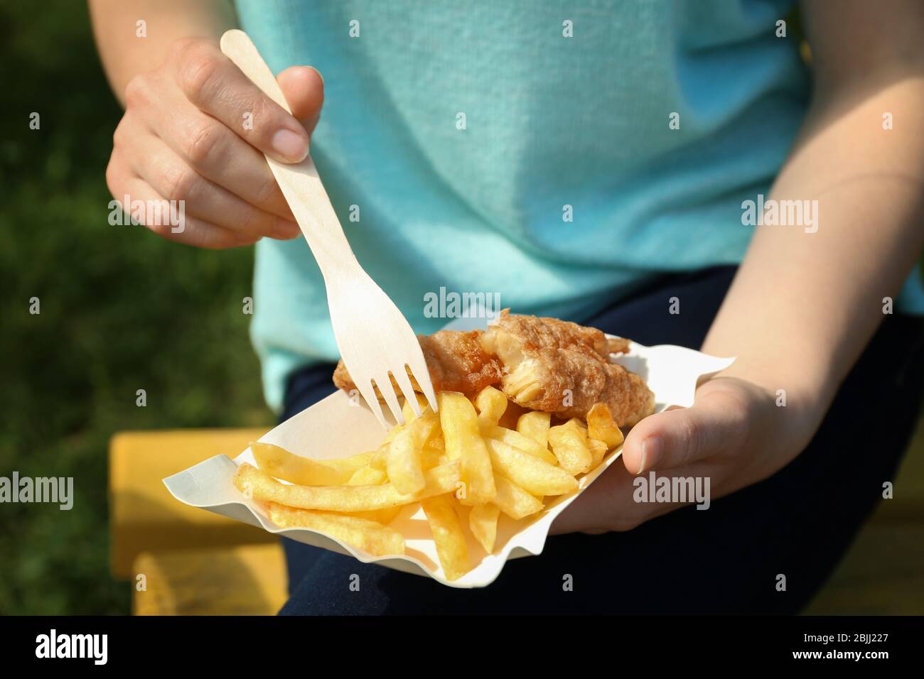 Woman eating fish and chips outdoors Stock Photo - Alamy