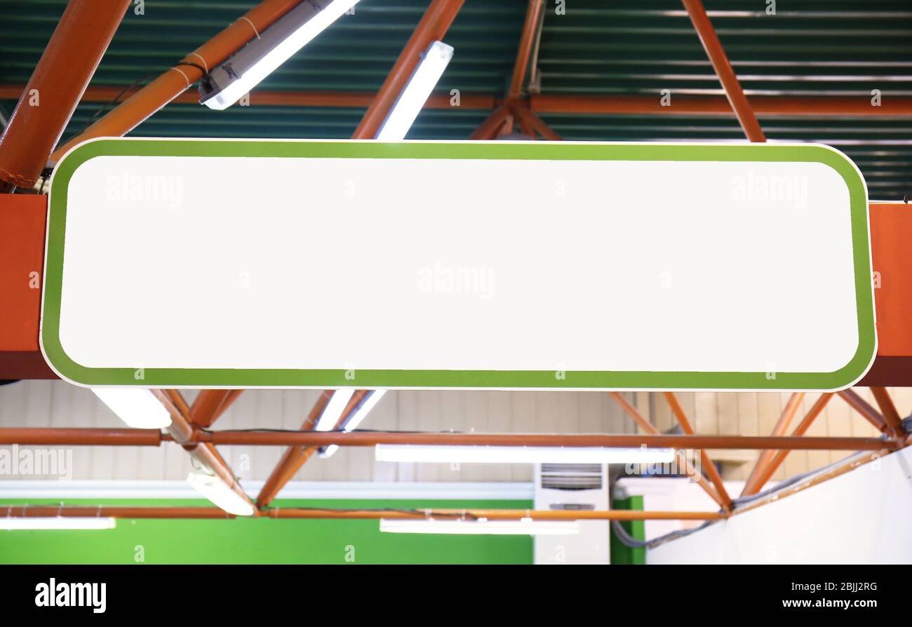 Blank signboard hanging on ceiling in shop Stock Photo - Alamy