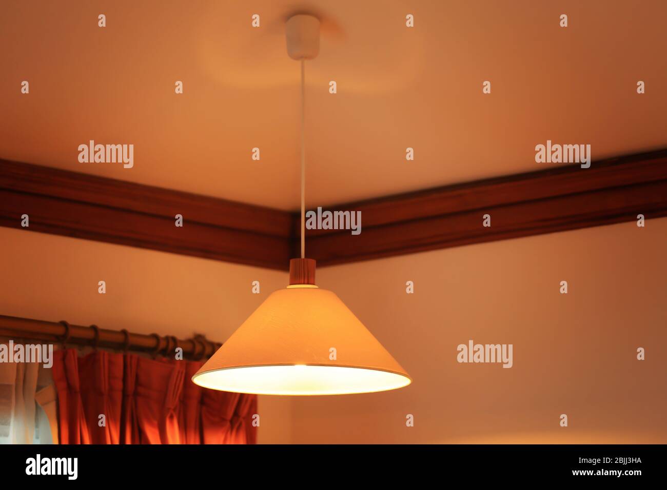 Lamp hanging on ceiling in room Stock Photo - Alamy