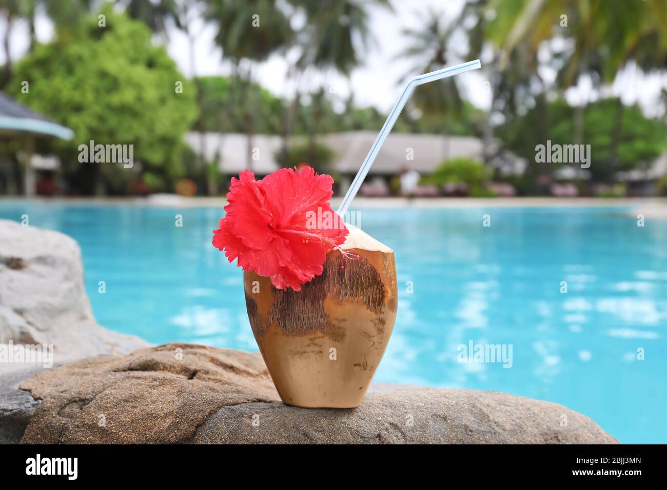 Fresh coconut cocktail near pool at resort Stock Photo - Alamy