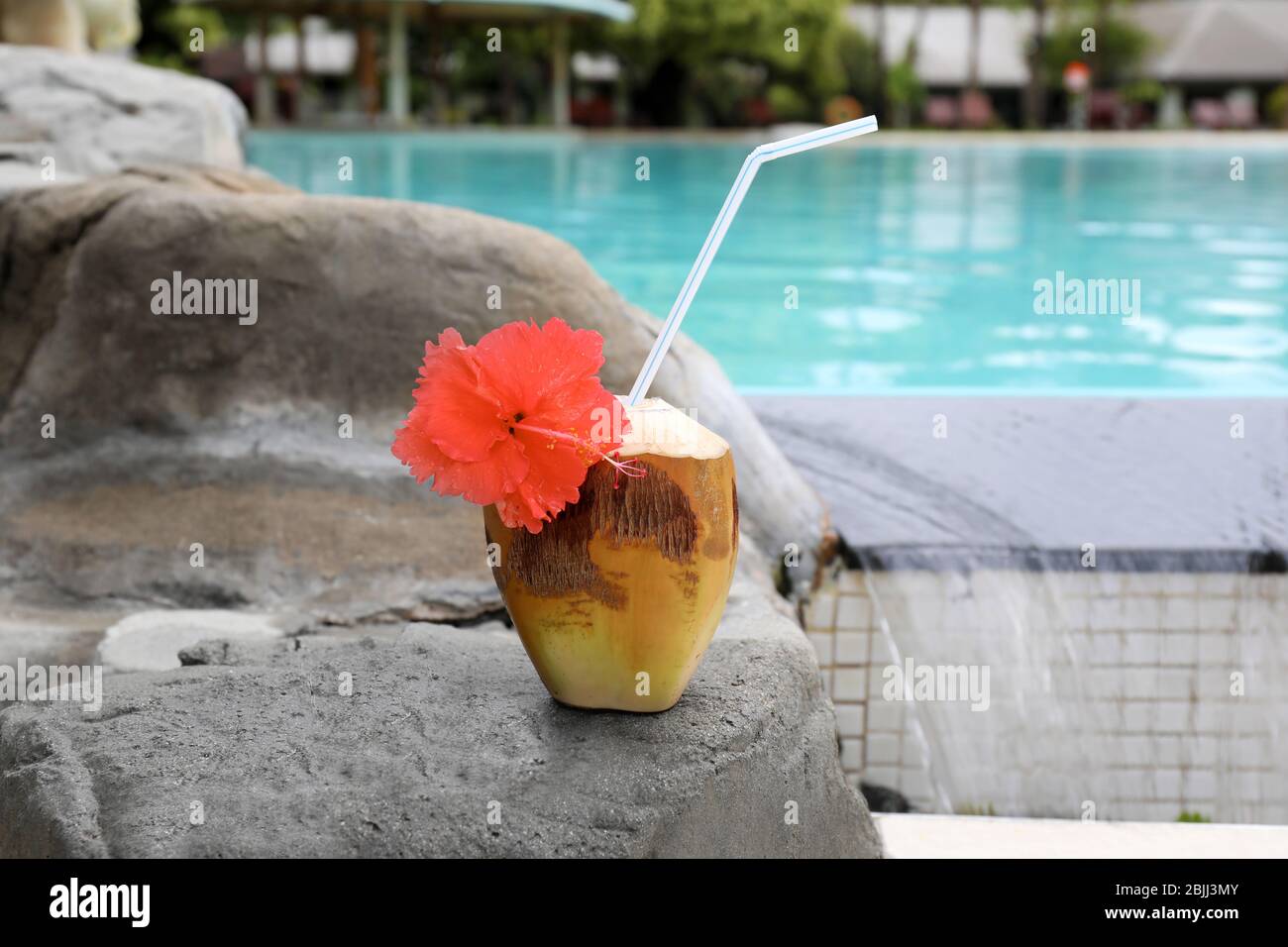 Fresh coconut cocktail near pool at resort Stock Photo - Alamy