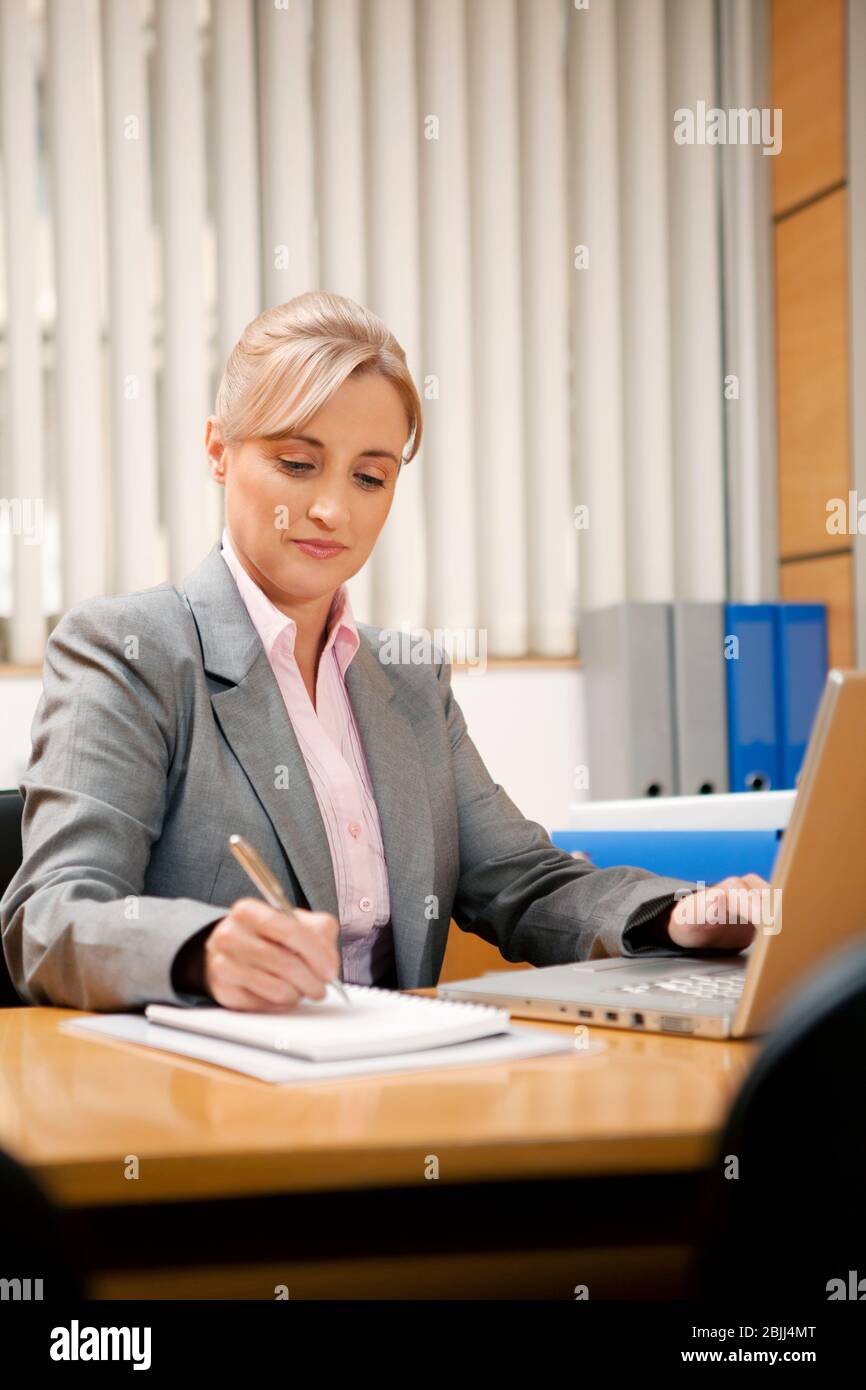 Female executive making notes Stock Photo - Alamy