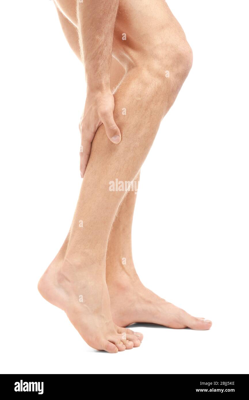 Young man suffering from pain in leg on white background Stock Photo ...