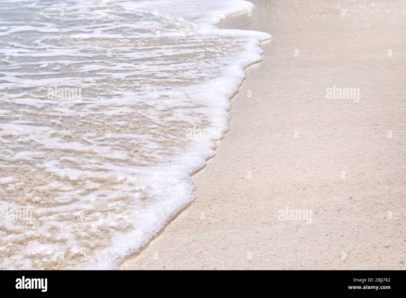 Warm sand and sea waves on beach at resort, closeup Stock Photo - Alamy