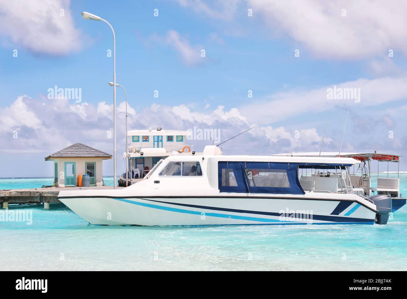Modern boat berthed at tropical resort Stock Photo - Alamy