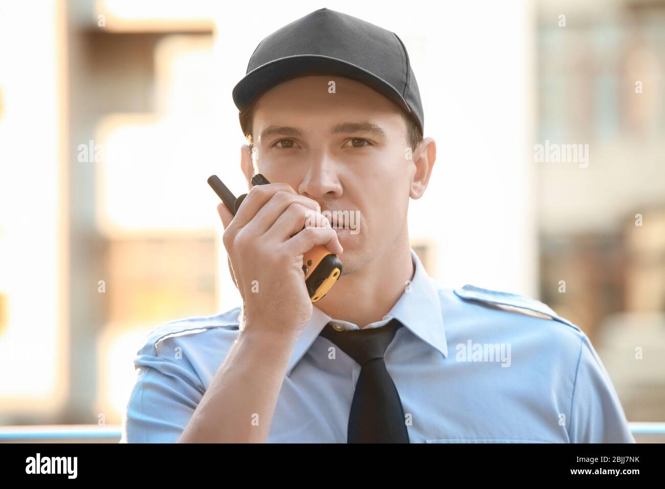 Male security guard with portable radio, outdoors Stock Photo - Alamy