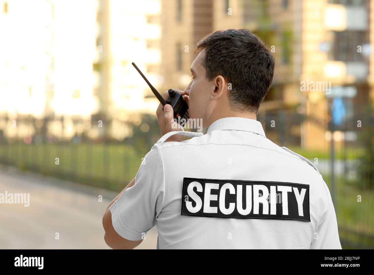 Male security guard with portable radio, outdoors Stock Photo - Alamy