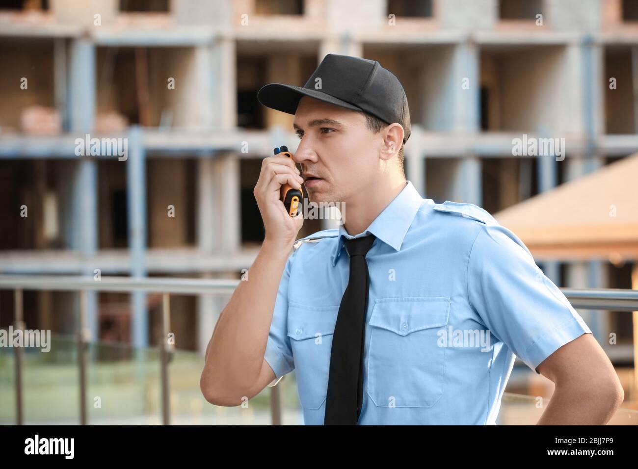Male security guard with portable radio, outdoors Stock Photo - Alamy