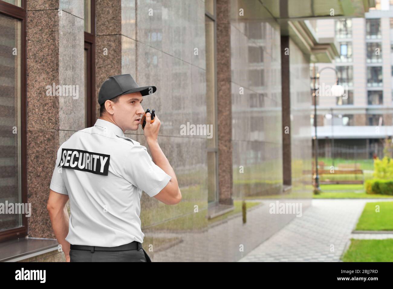 Male security guard with portable radio, outdoors Stock Photo - Alamy
