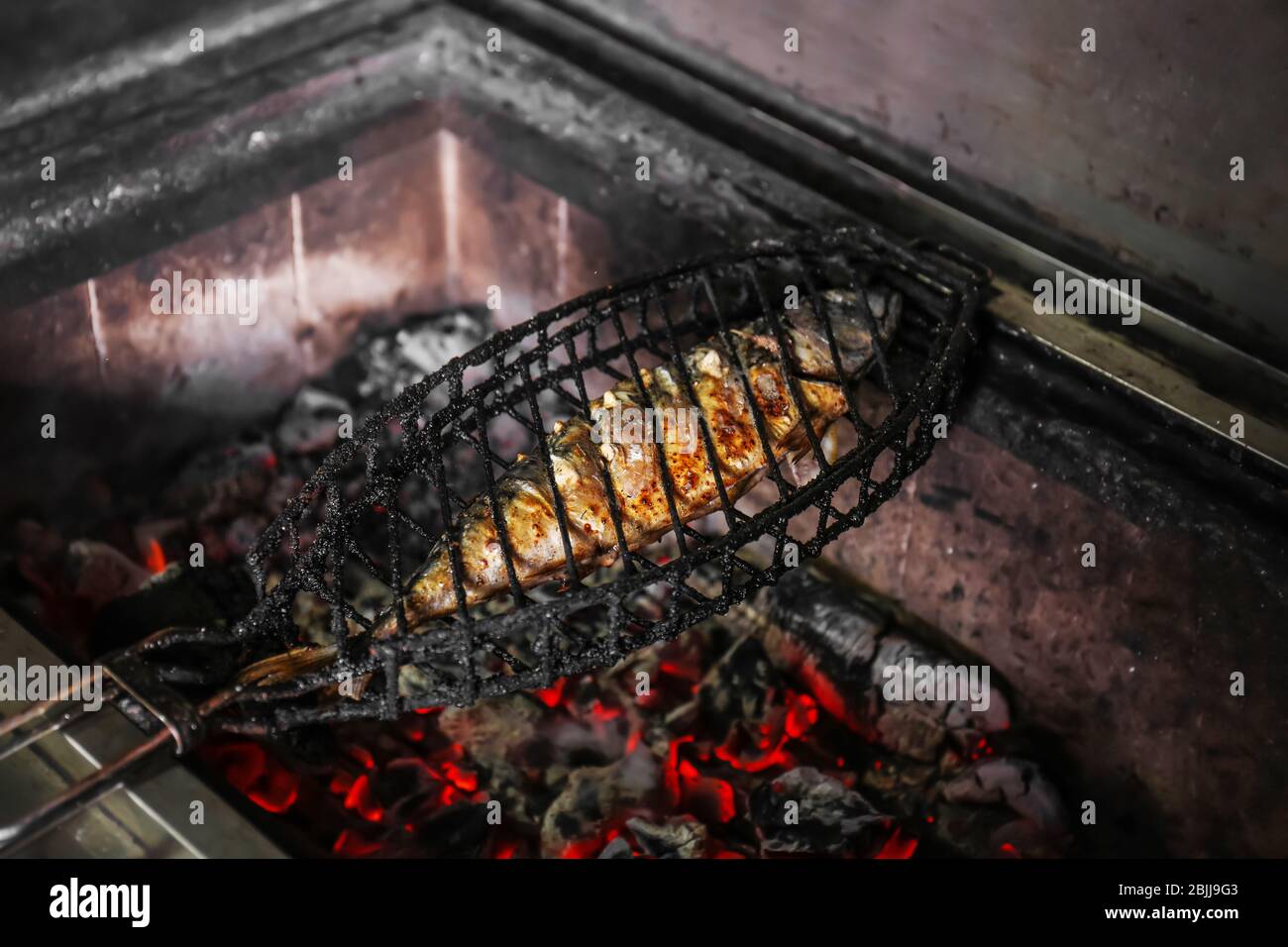 Grilled fish with spices cooking over fire Stock Photo - Alamy
