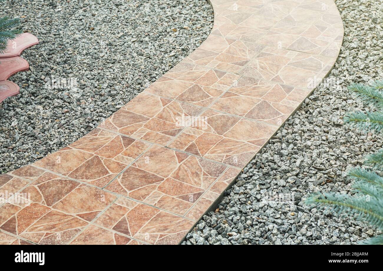 Pathway made from ceramic tiles with crushed stone in garden Stock ...