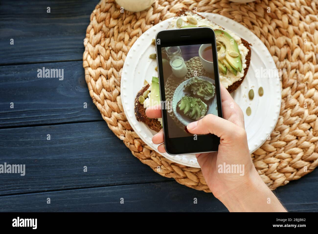 Young woman taking photo of delicious toasts with mobile phone Stock ...